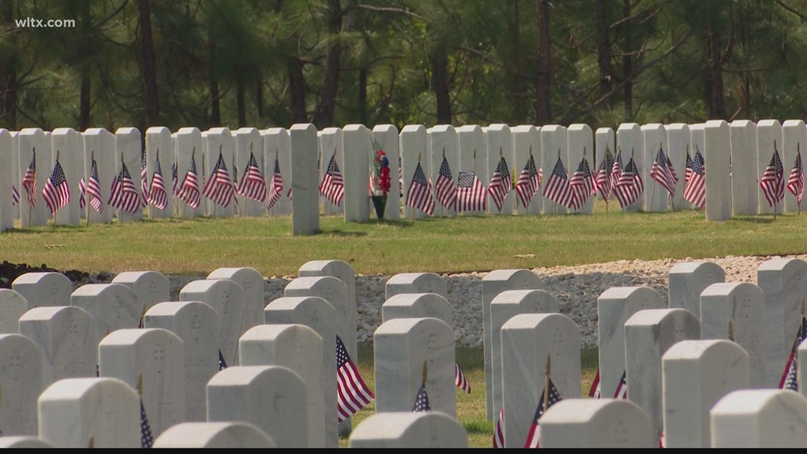 Volunteers place flags at Fort Jackson National cemetery | wltx.com